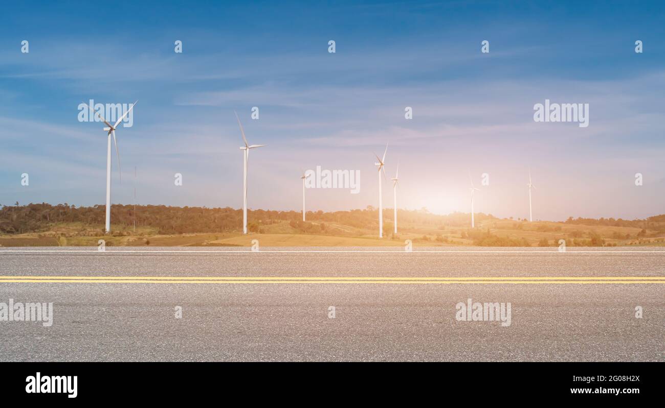 Asphalt road with wind turbines at sunset background Stock Photo - Alamy