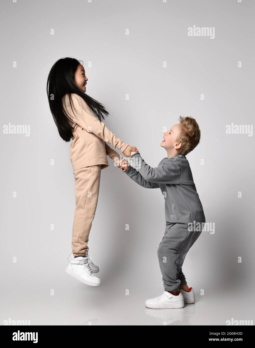 Kids in cosy cotton sportswear play together. Laughing blond kid boy ...