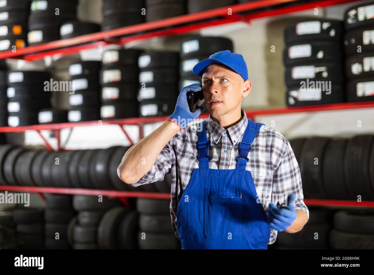 Car mechanic calls on smartphone to client Stock Photo - Alamy