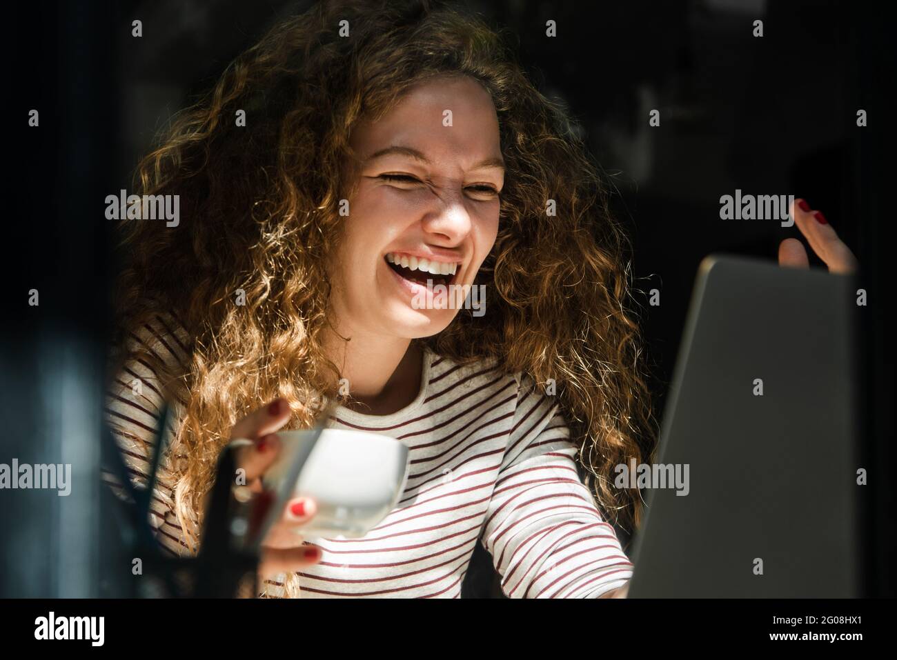 Happy positive Caucasian woman laughing while making a video call in ...