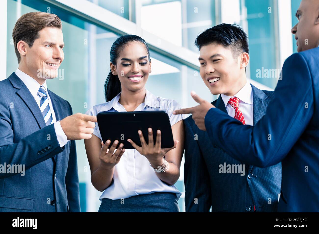 Informal business people with table computer discussing in front of ...