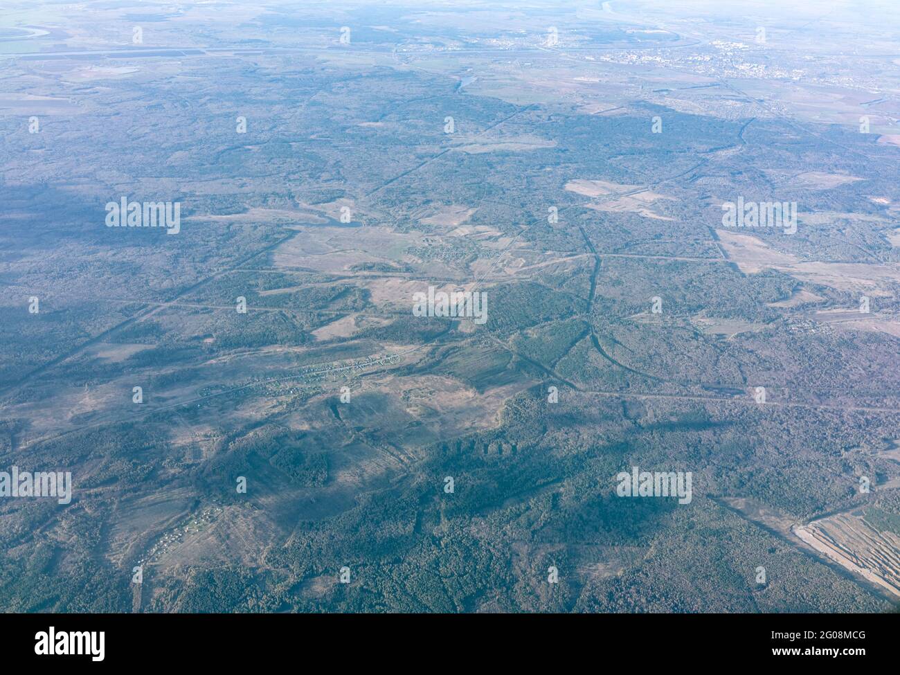 Aerial view from airplane window above green ground. View from the ...