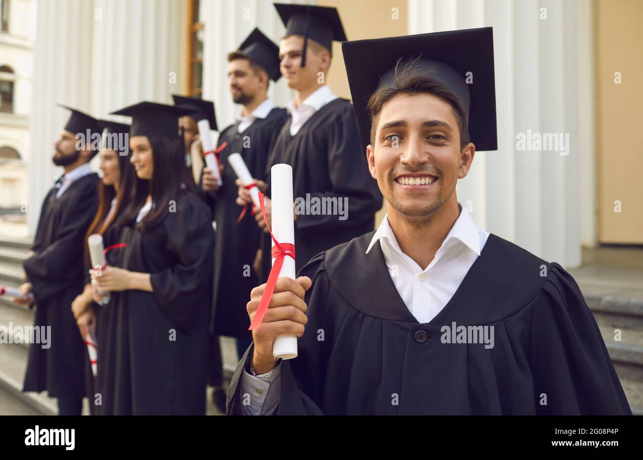 Young graduate in cap and gown with diploma hi-res stock photography ...