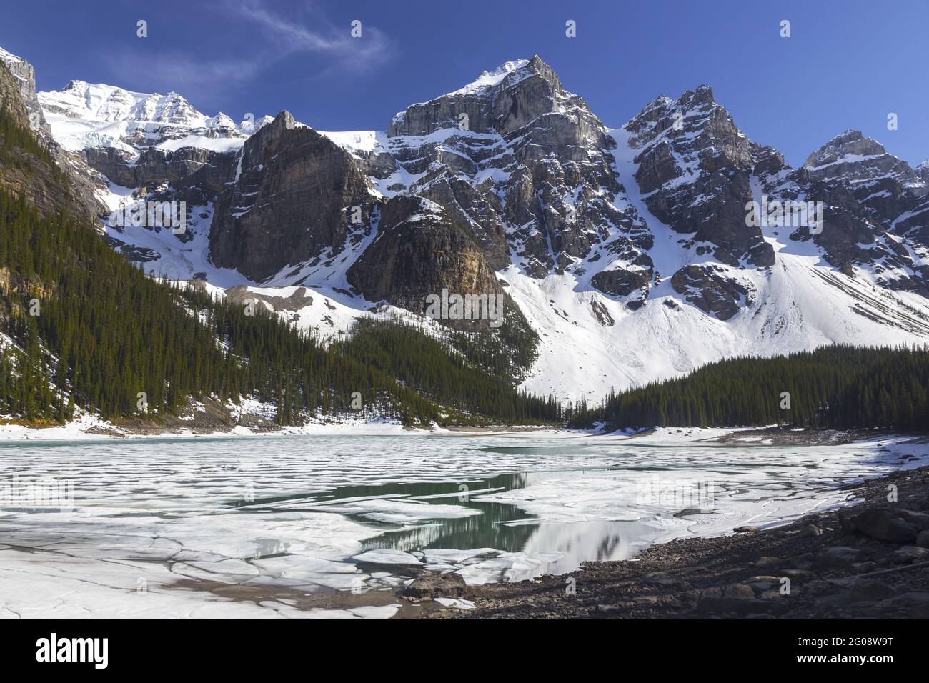 Valley of Ten Peaks Mountains above Ice Covered Frozen Moraine Lake Melting Water. Banff ...