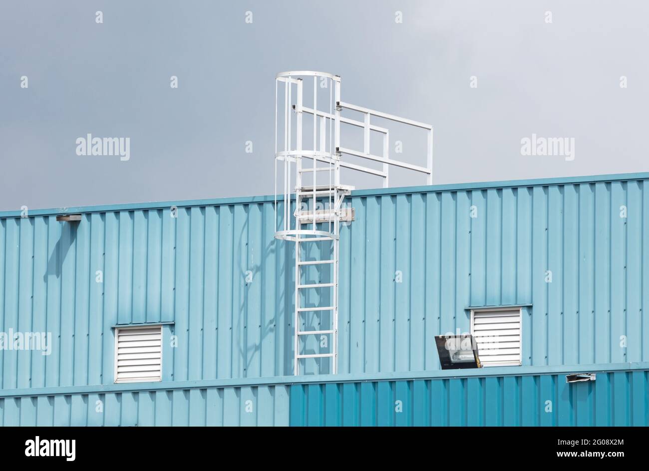 Fire emergency escape ladder on a blue building Stock Photo - Alamy