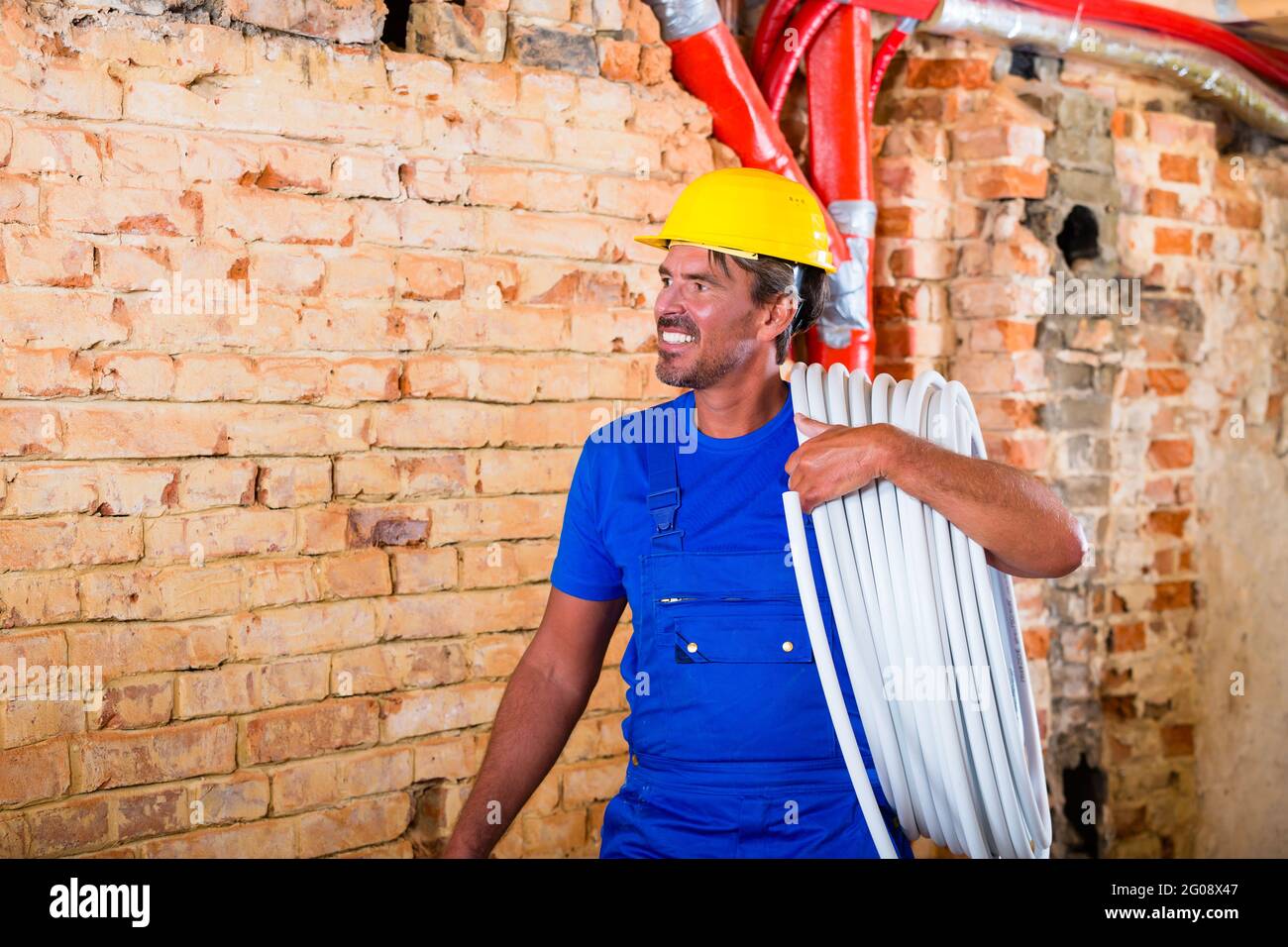 Builder working on construction site with hose over his shoulder Stock ...