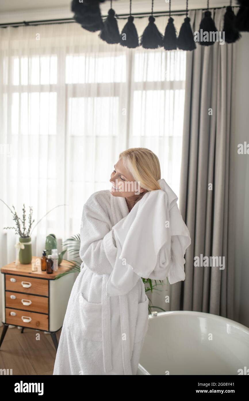 Smiling blonde woman drying her hair with a towel after the bath Stock ...