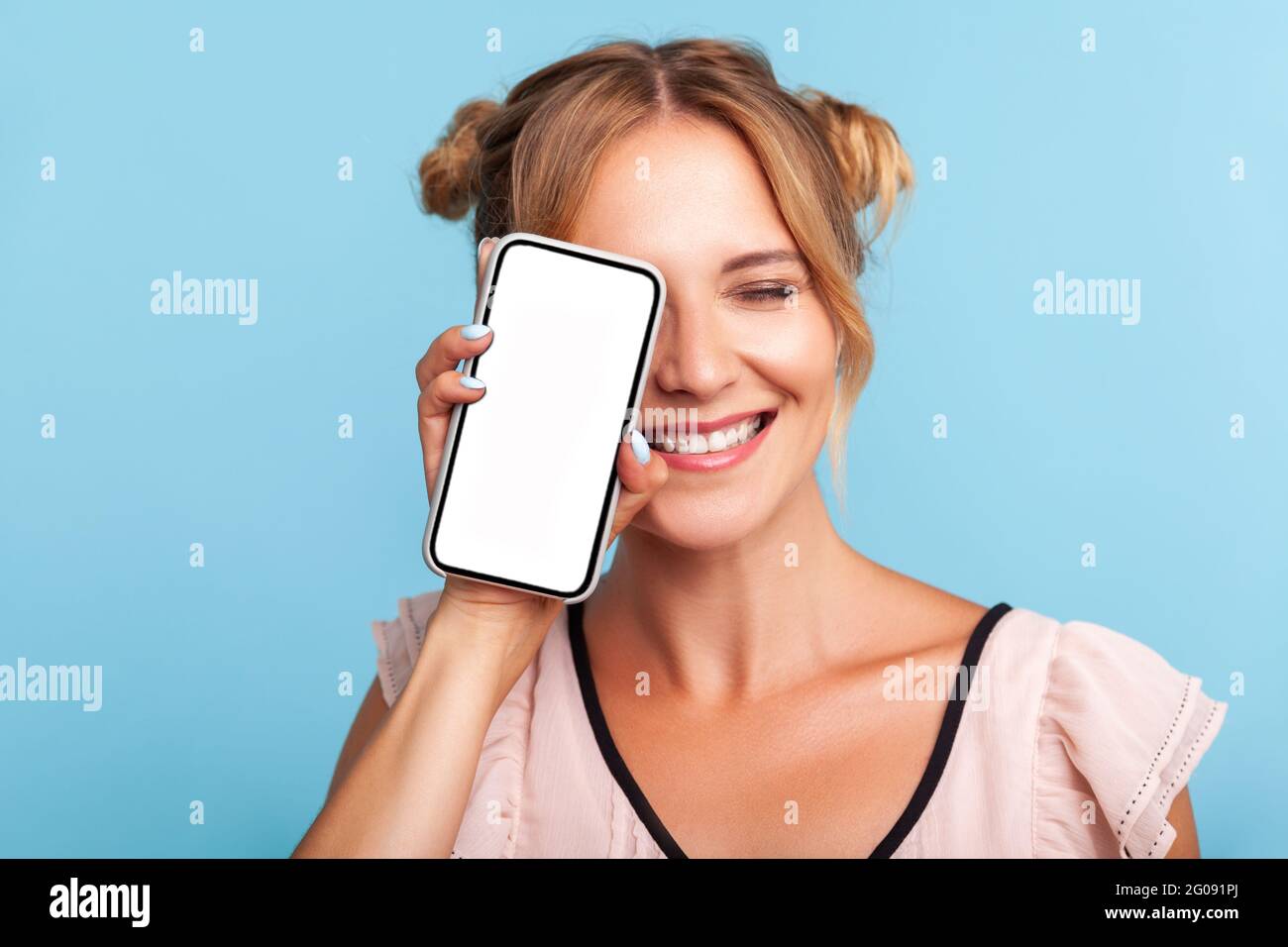 Portrait of joyful blonde female with two buns hairstyle in summer ...