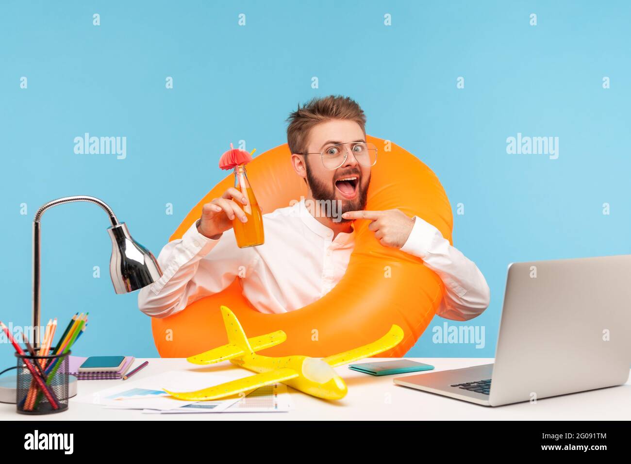 Excited man office worker sitting at workplace with rubber lifebuoy and ...