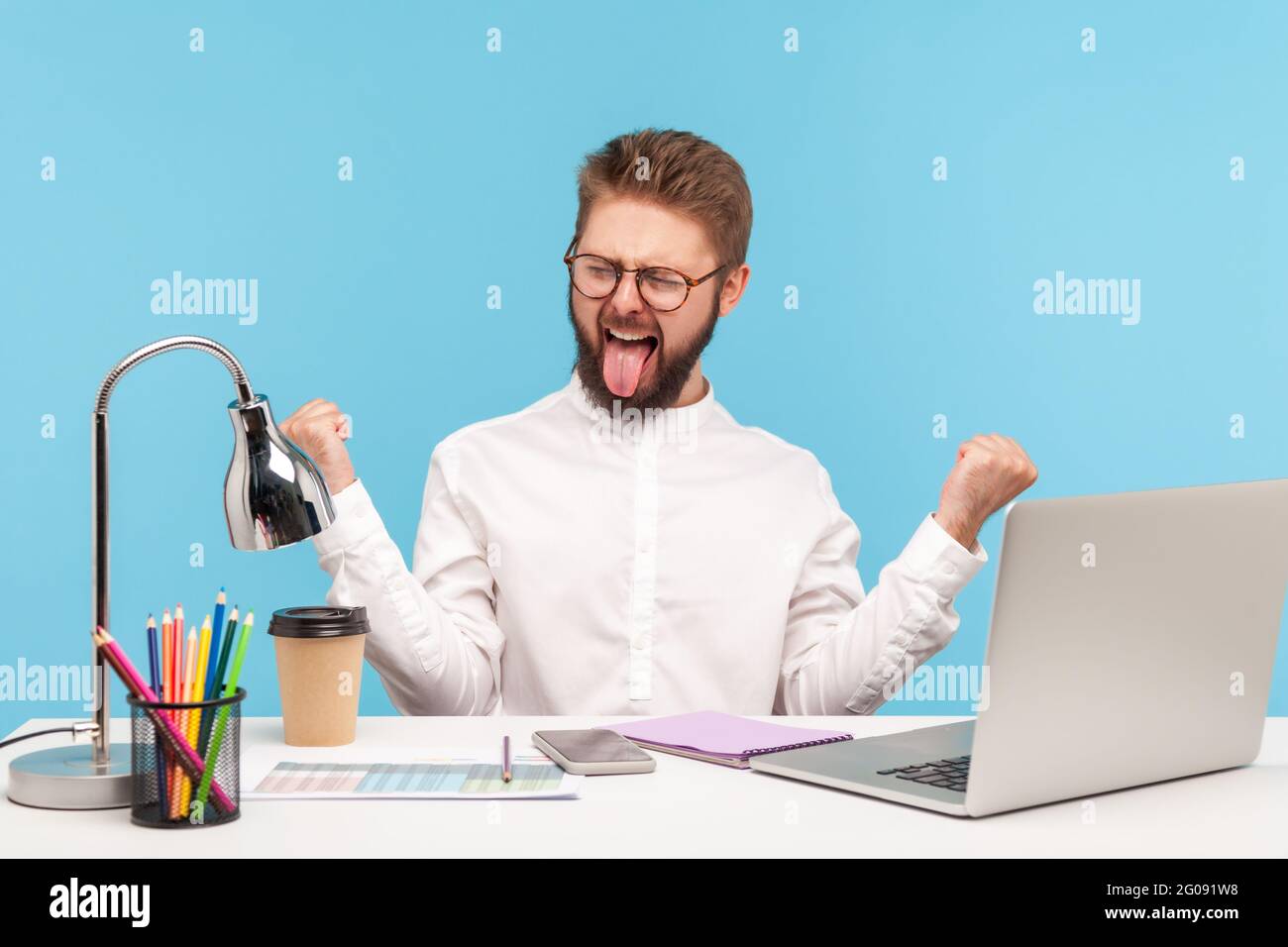 Extremely positive satisfied man office worker showing tongue out ...