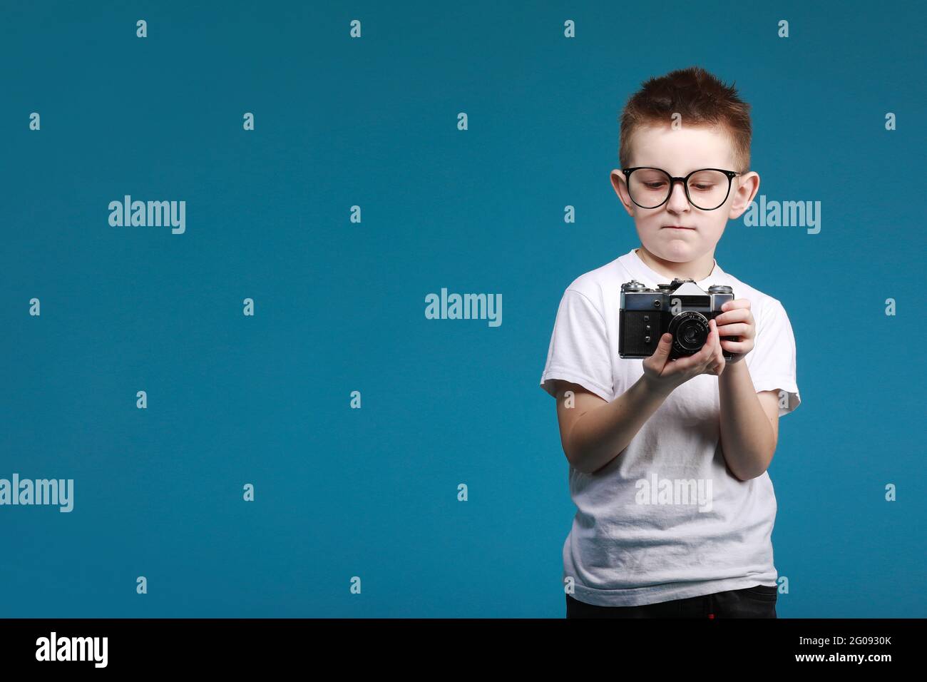 Little boy taking a picture using a retro camera. Child boy with ...