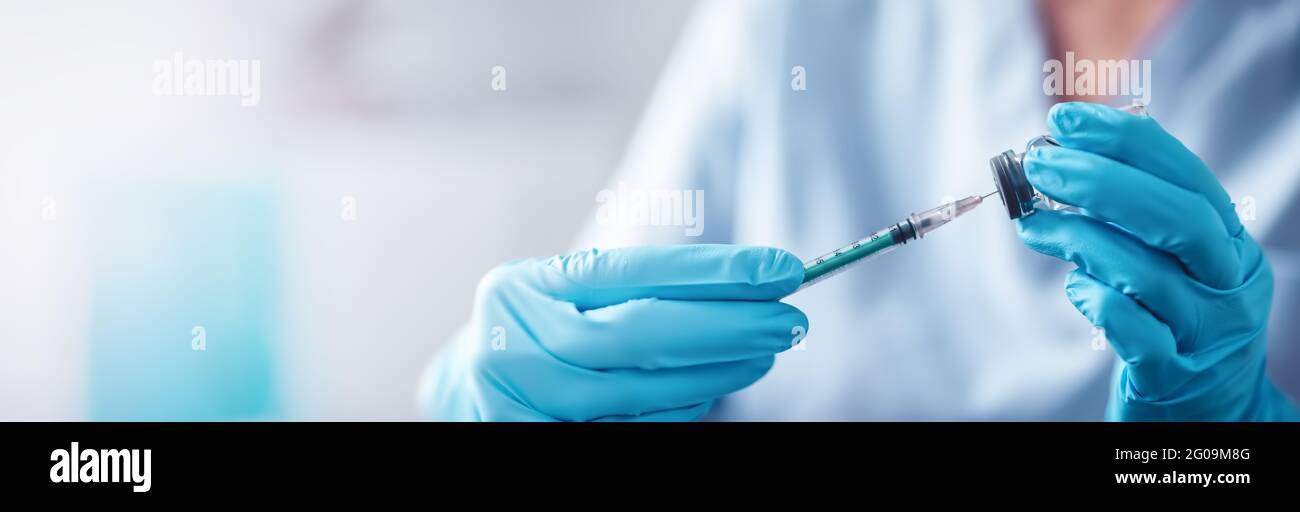 Nurse in surgical gloves holding an injection needle Stock Photo - Alamy