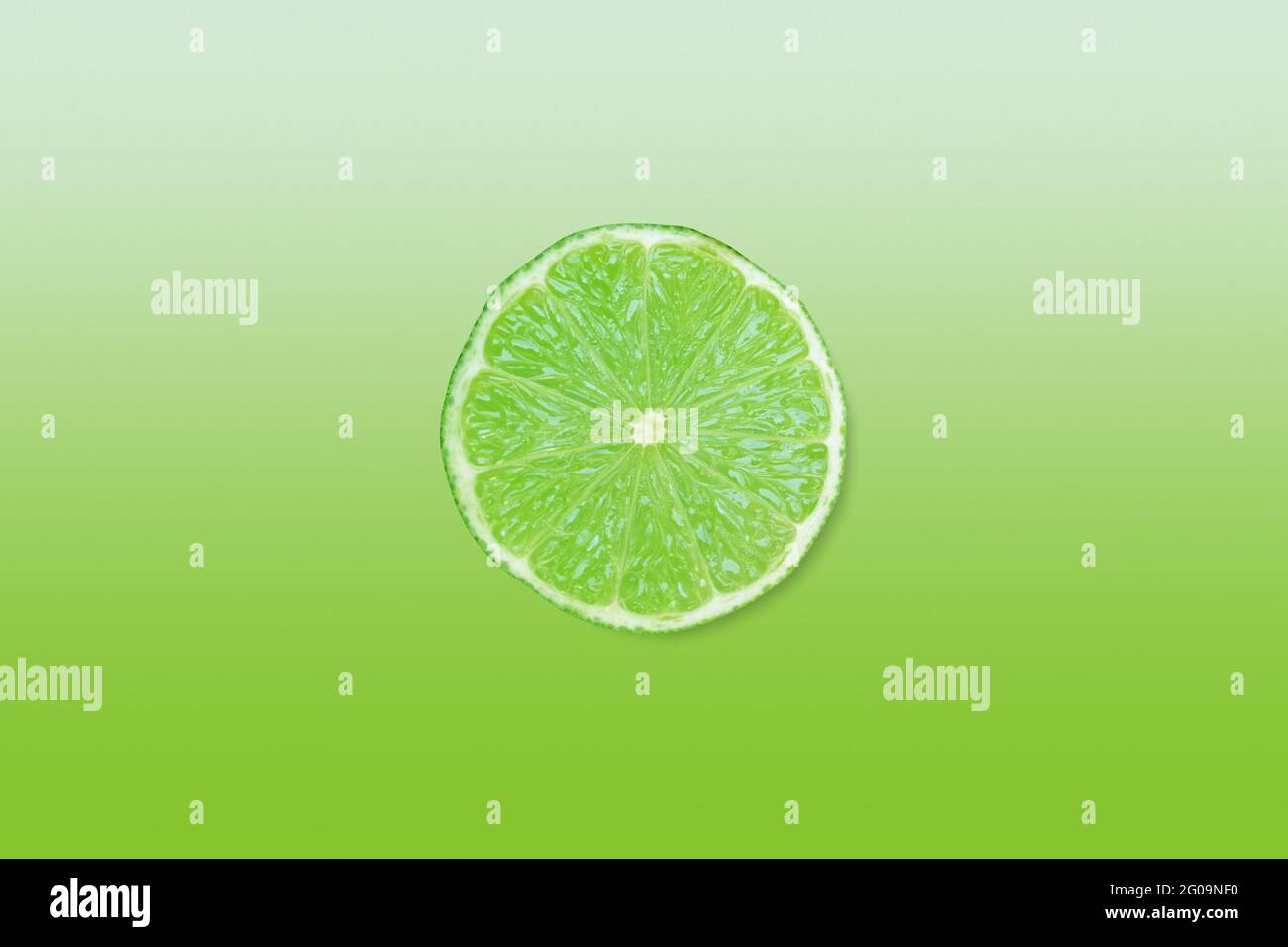 green lime slice over matching colour gradient background with copy ...