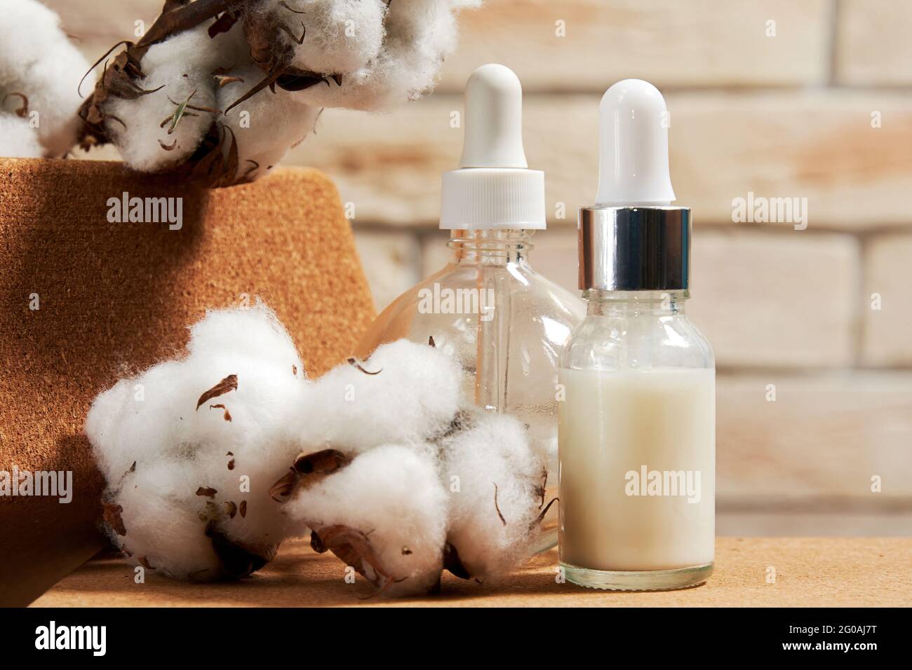 Facial cosmetics milk in the glass flasks on the desk with cotton twigs ...
