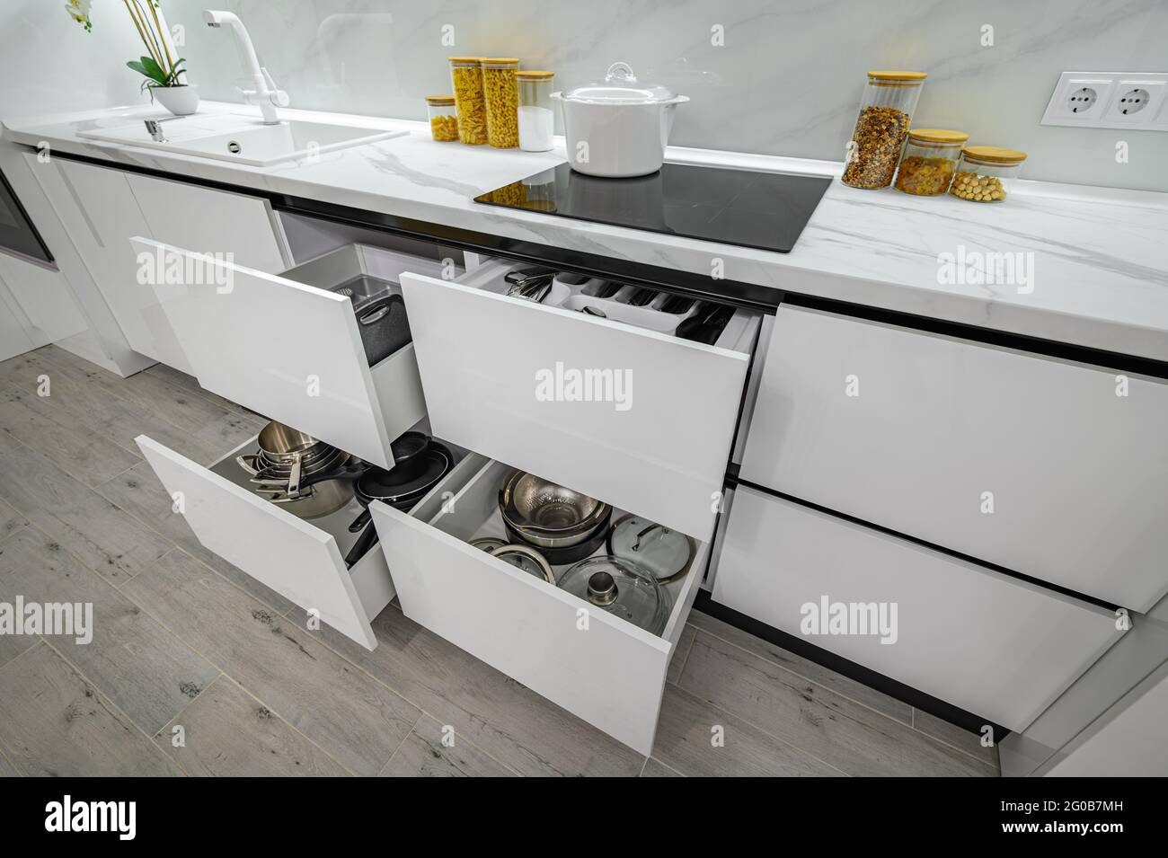Luxurious white and black modern kitchen interior, drawers pulled out ...