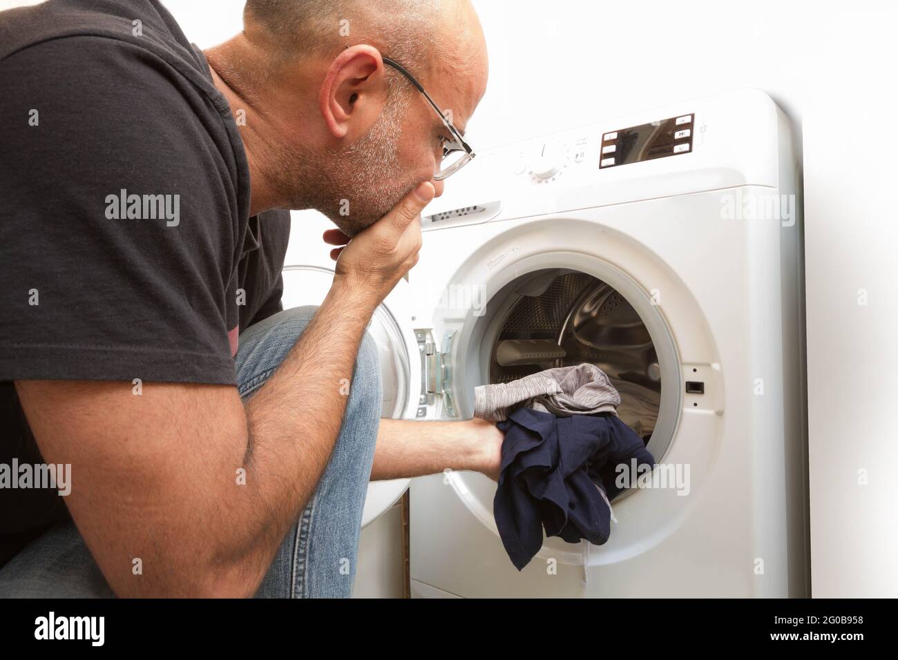 Male loading the washing machine with dirty clothes Stock Photo - Alamy