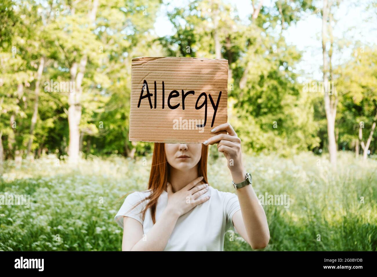 Young redhead woman covers her face with sign text allergy. Faceless ...
