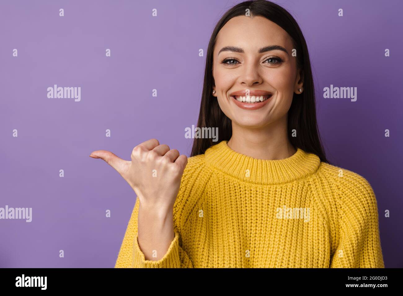 Happy nice girl smiling while pointing finger aside isolated over ...