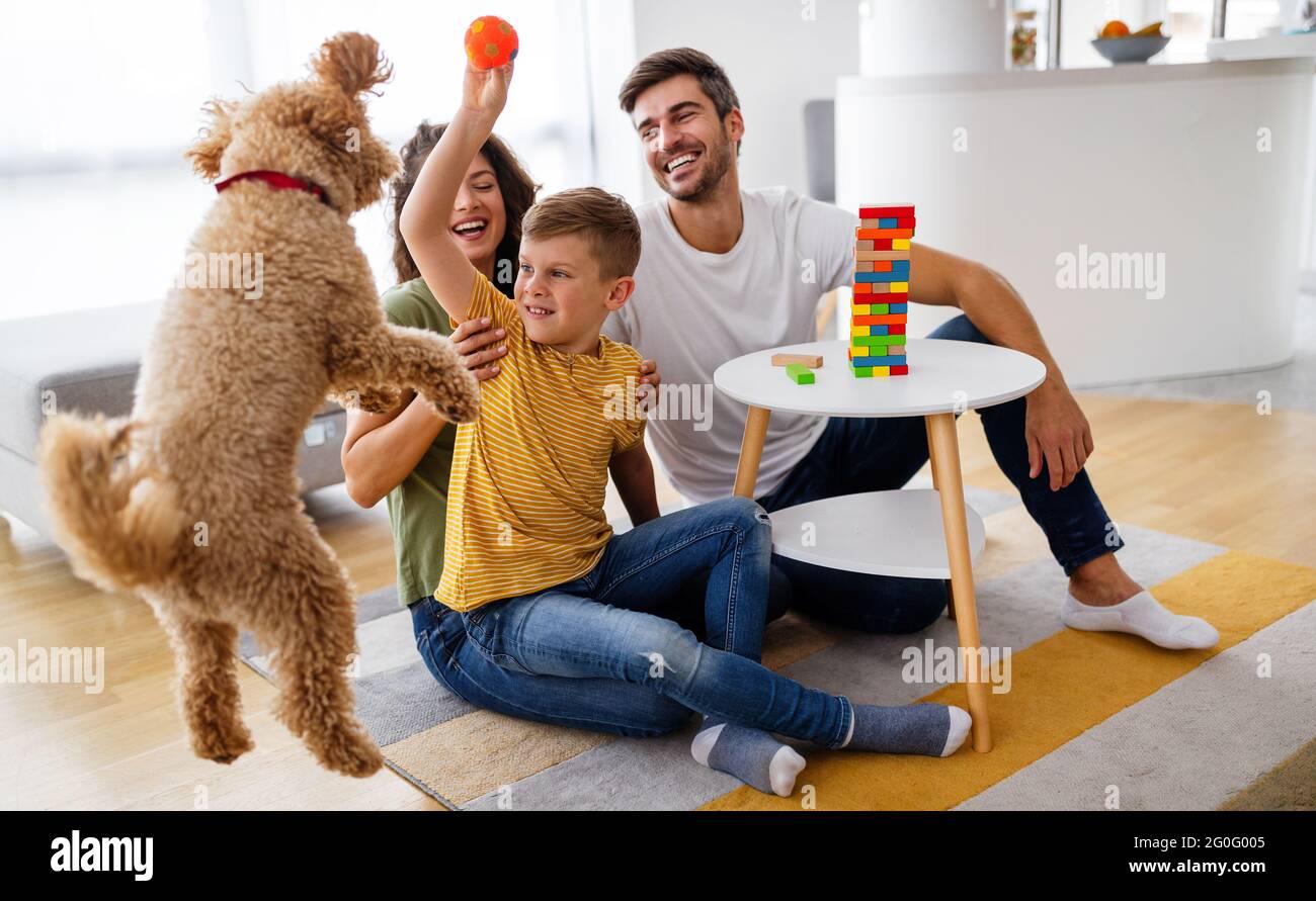 Happy family having fun time, playing together at home with dog Stock ...