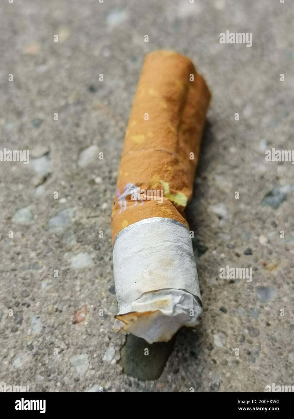 Vertical closeup shot of a burnt-out cigarette on the floor Stock Photo ...