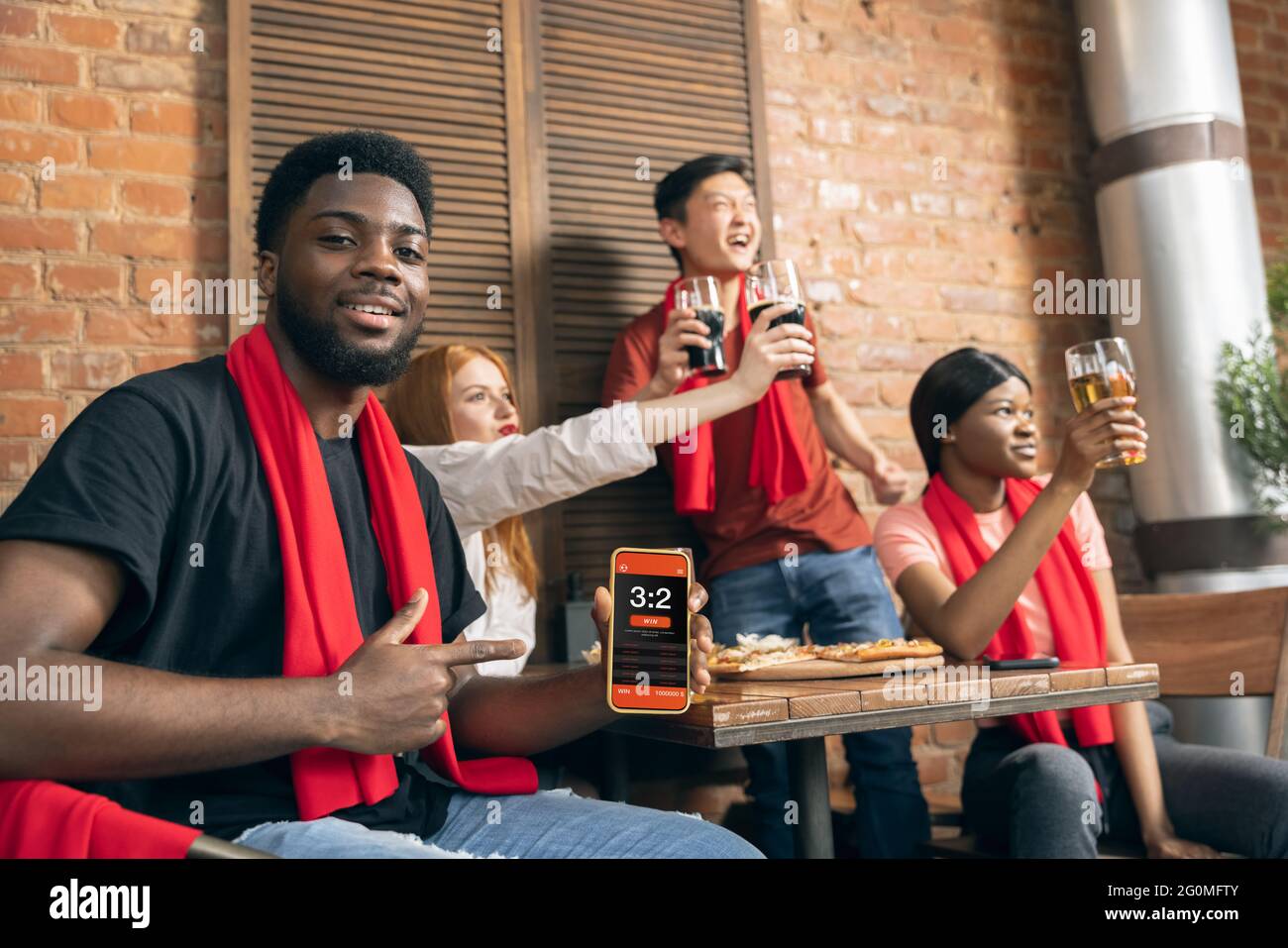 Four young people, sportive fans meeting together in bar, pub. Concept ...