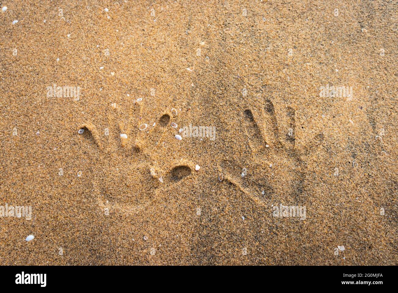 Couple hand prints on yellow sandy beach showing love for each other ...