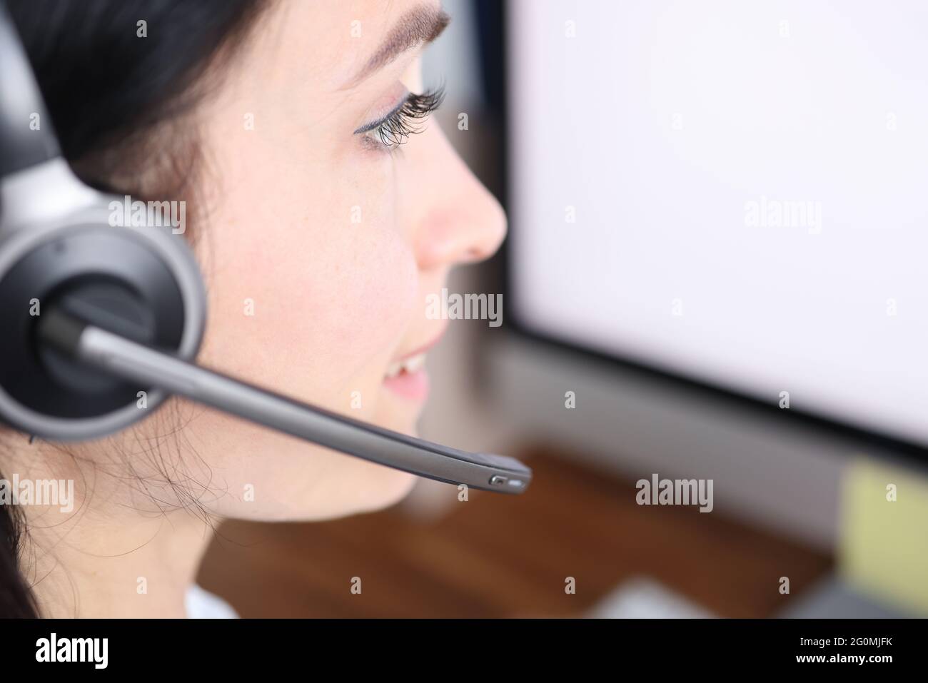 Woman call center operator behind computer monitor advises clients ...
