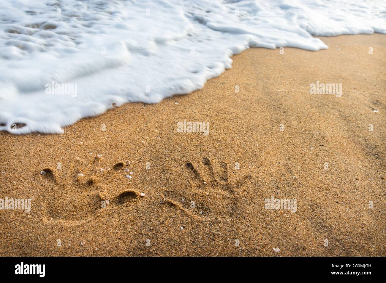 Couple hand prints on yellow sandy beach showing love for each other ...