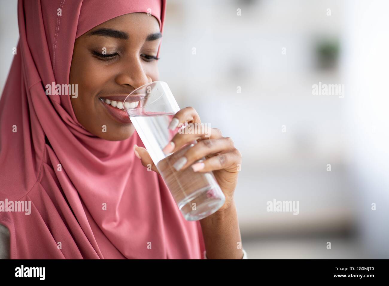 Black Muslim Woman In Hijab Drinking Water From Glass At Home, Closeup ...