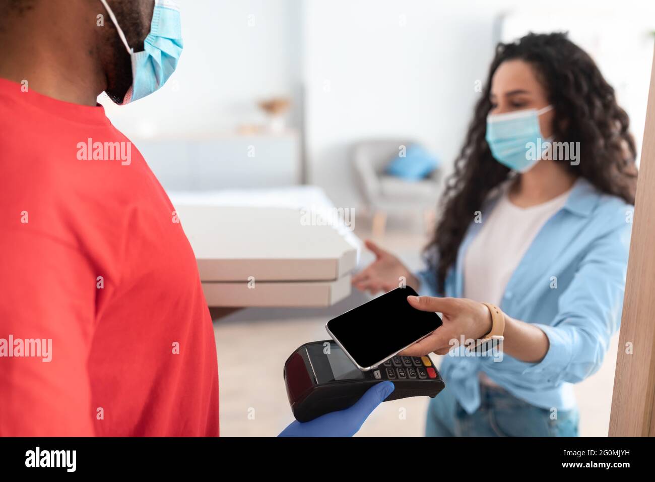 Black man holding POS machine client paying with smartphone Stock Photo ...