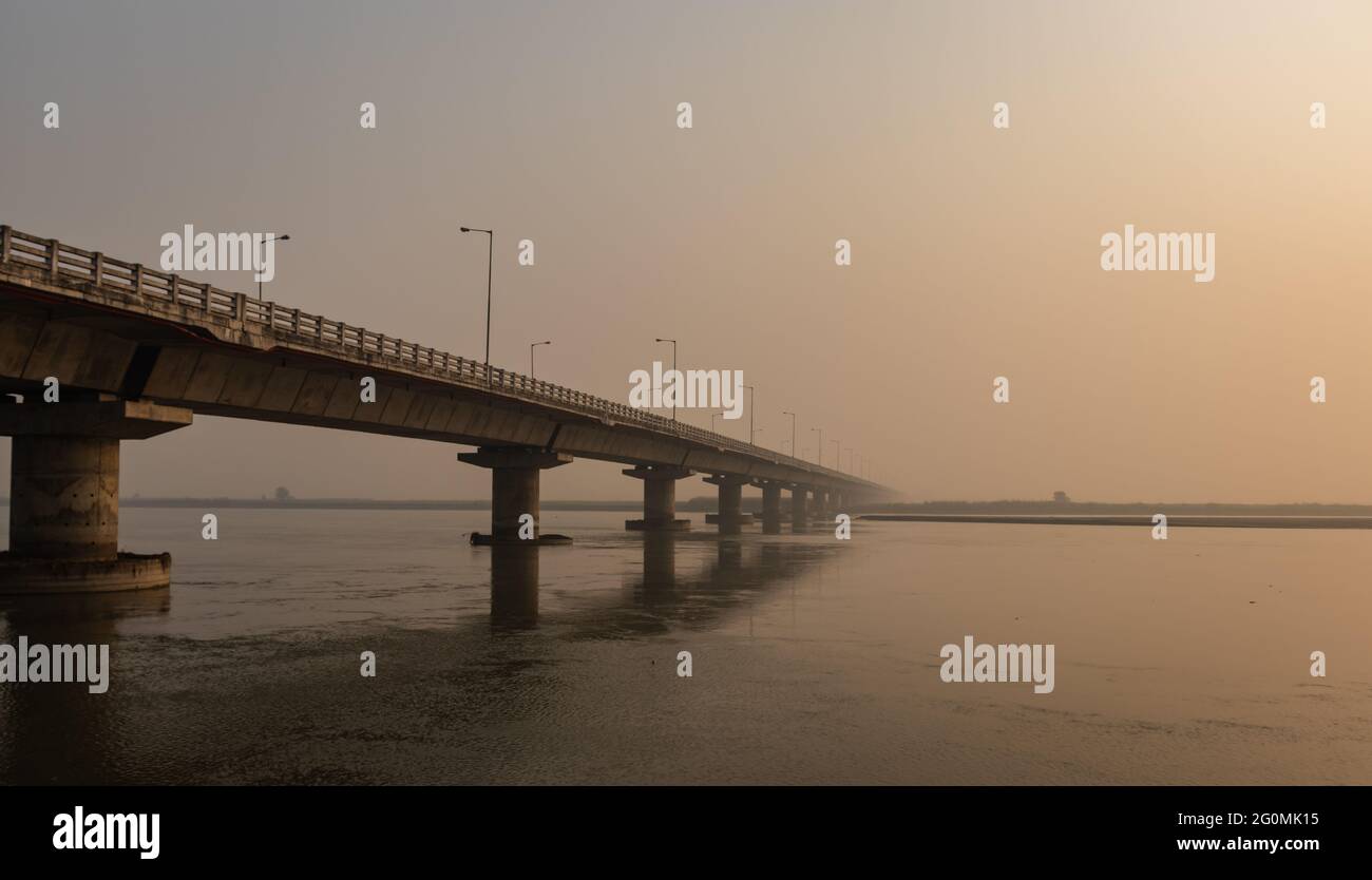road bridge over river with its water reflection at dawn from low angle ...