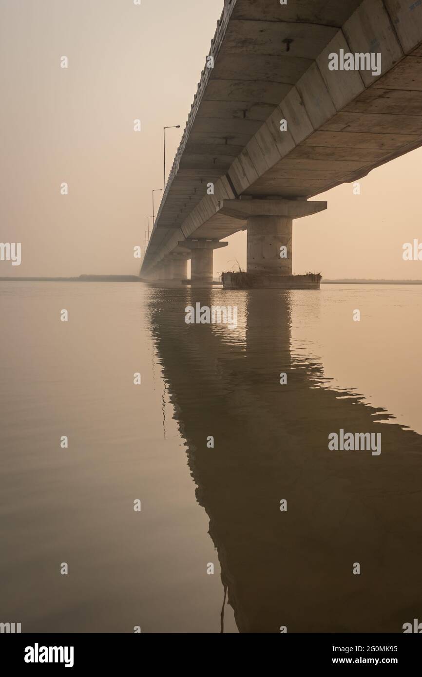 road bridge over river with its water reflection at dawn from low angle ...