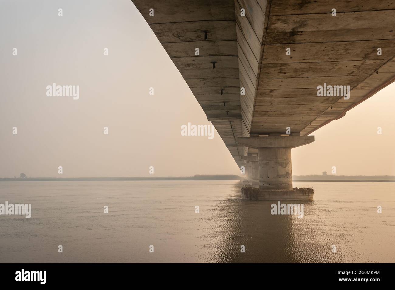 road bridge over river with its water reflection at dawn from low angle ...