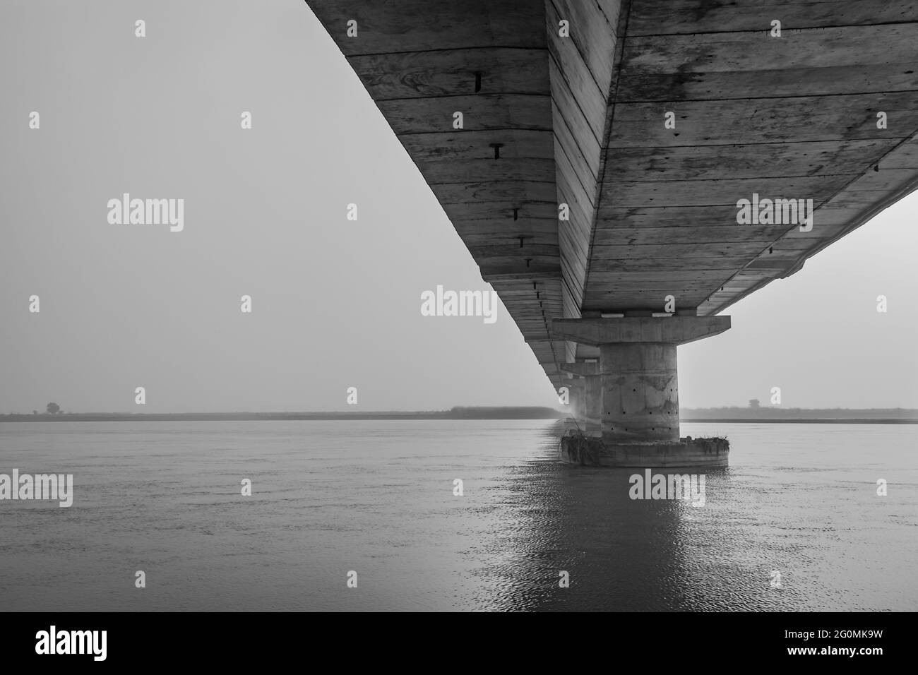 road bridge over river with its water reflection at dawn from low angle ...