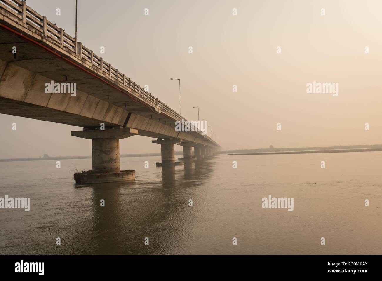 road bridge over river with its water reflection at dawn from low angle ...