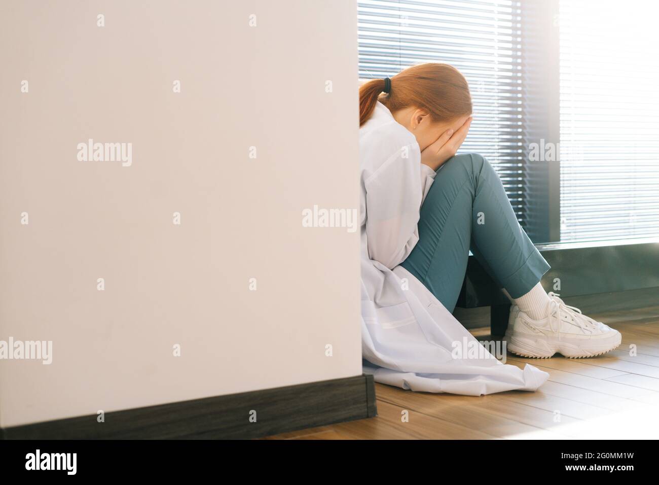 Close-up back view of sad depressed female doctor crying sitting near ...