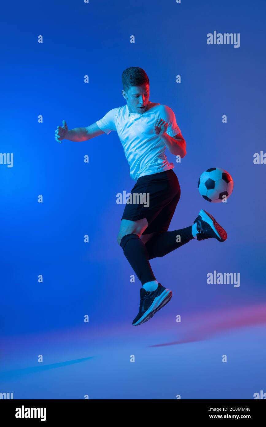 Young Caucasian man, male soccer football player jumping isolated on ...