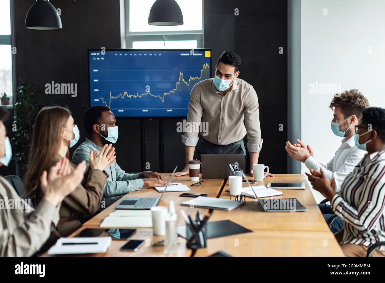 Colleagues having meeting in boardroom, clapping hands, businessman ...