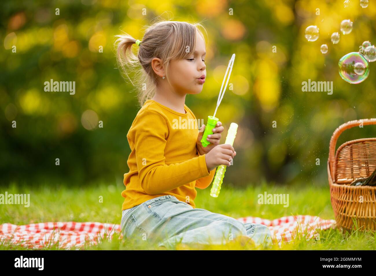 Happy little kid blowing soap bubble in park.People,fun and nature ...