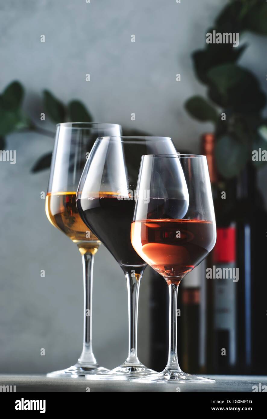 Wines assortment. Red, white, rose wine in wineglasses and bottles on ...