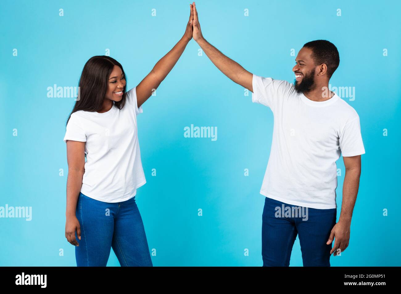 Portrait of happy black couple celebrating win giving high five Stock ...