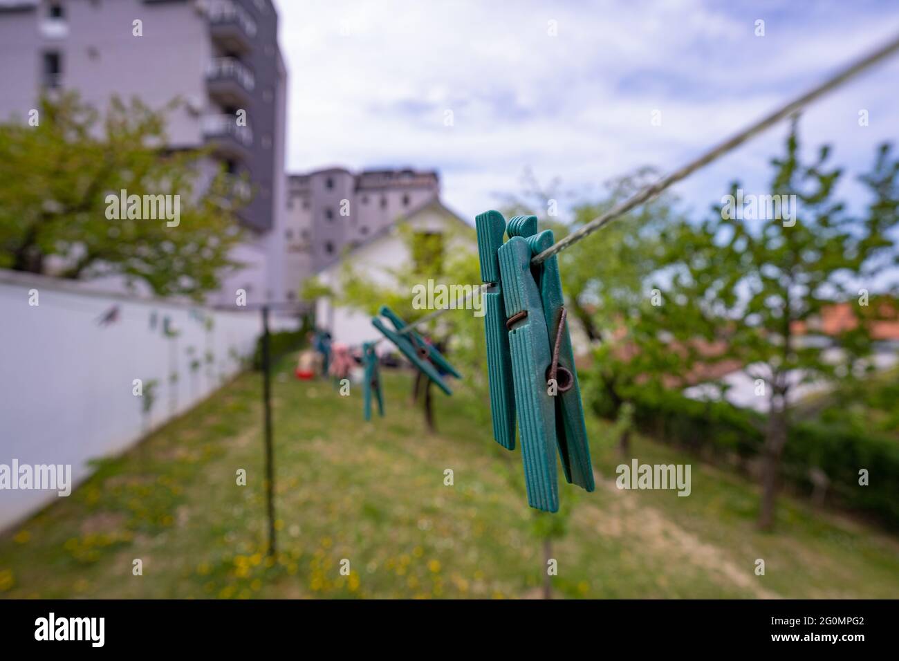 Clothes pin hanging from a wire in a household garden Stock Photo - Alamy