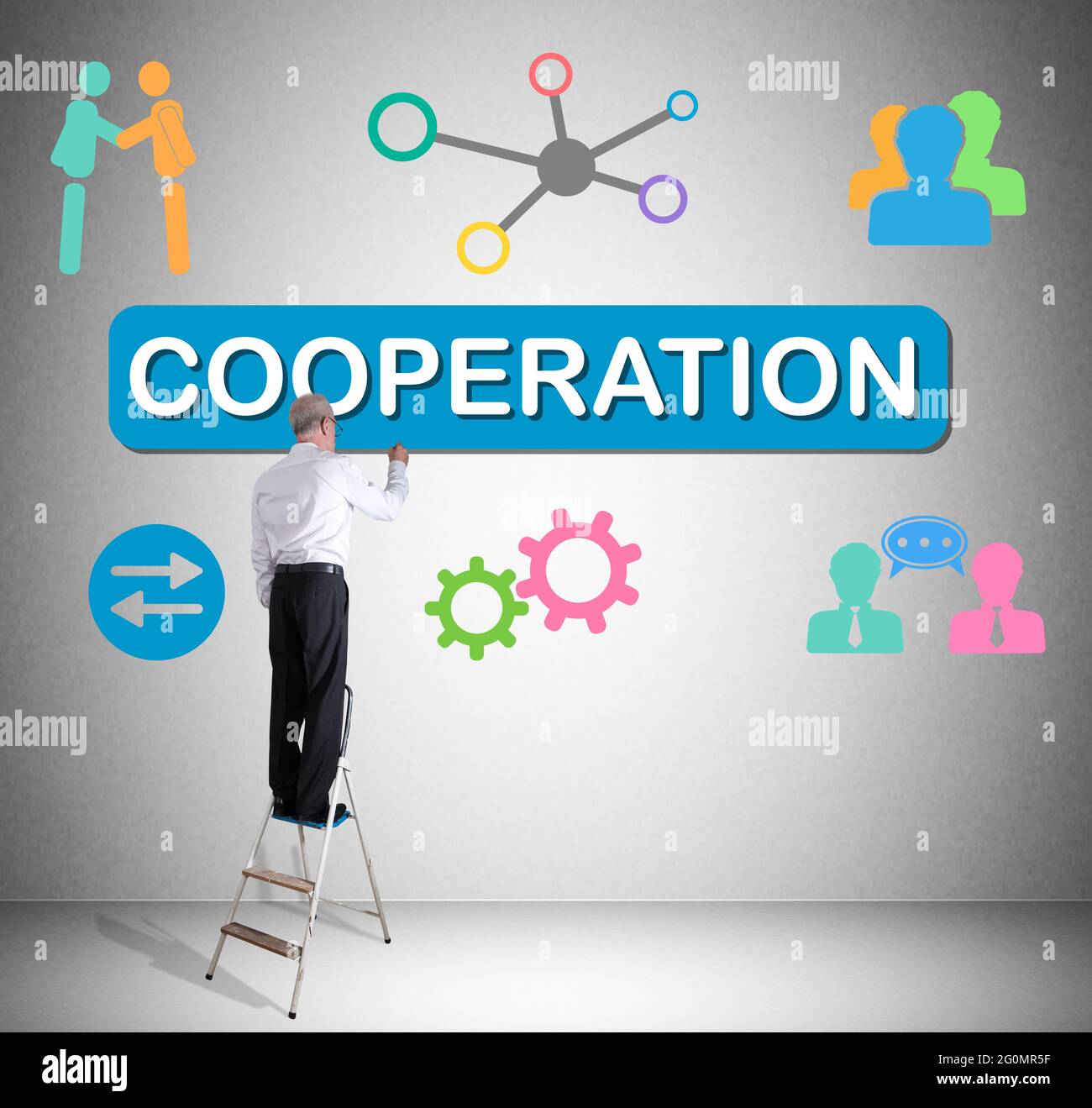 Man on a ladder drawing cooperation concept on a wall Stock Photo - Alamy