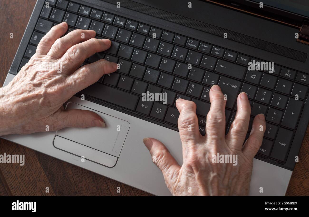 Old woman hands typing on a laptop keyboard Stock Photo - Alamy