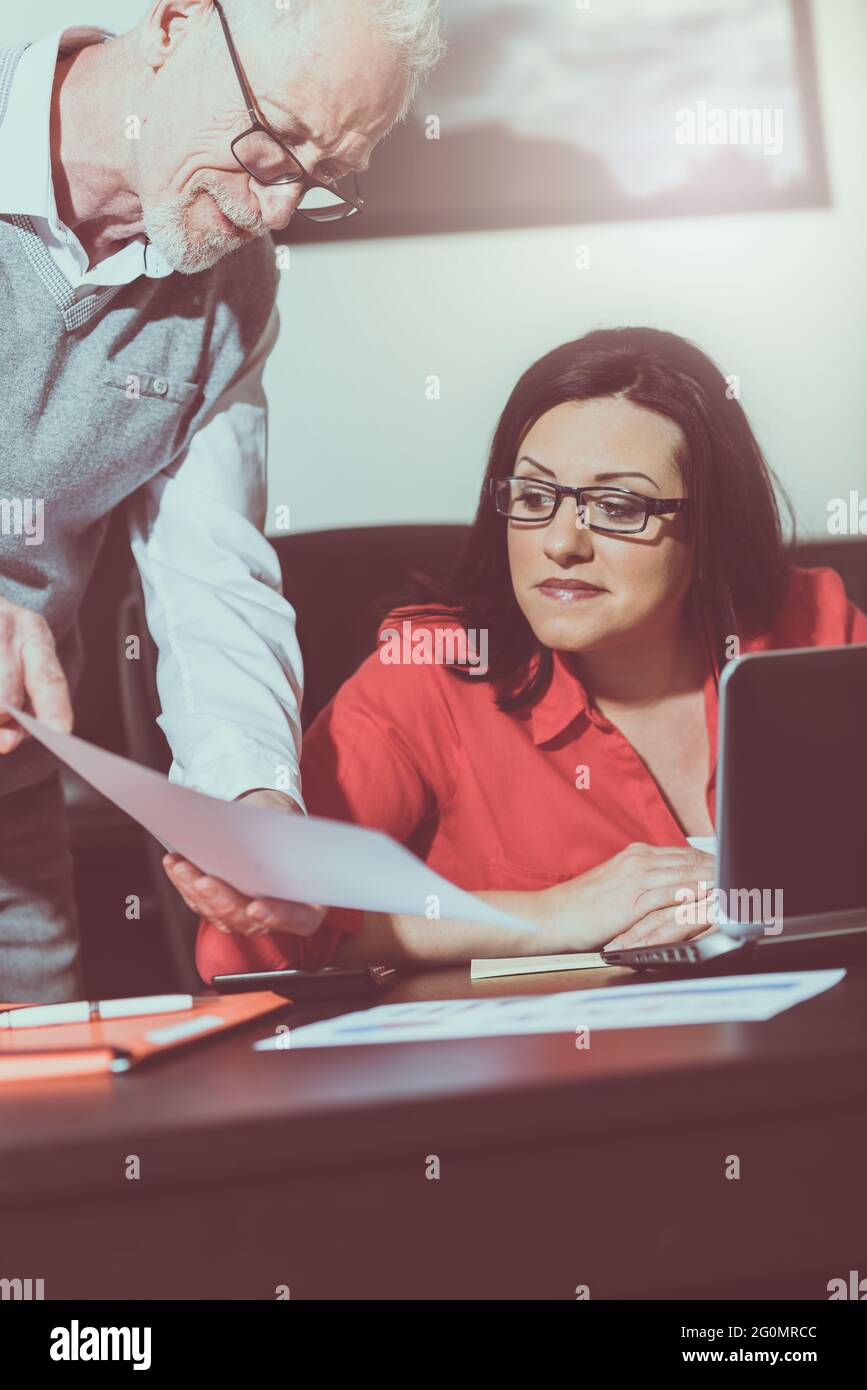 Young businesswoman and senior businessman working together at office ...