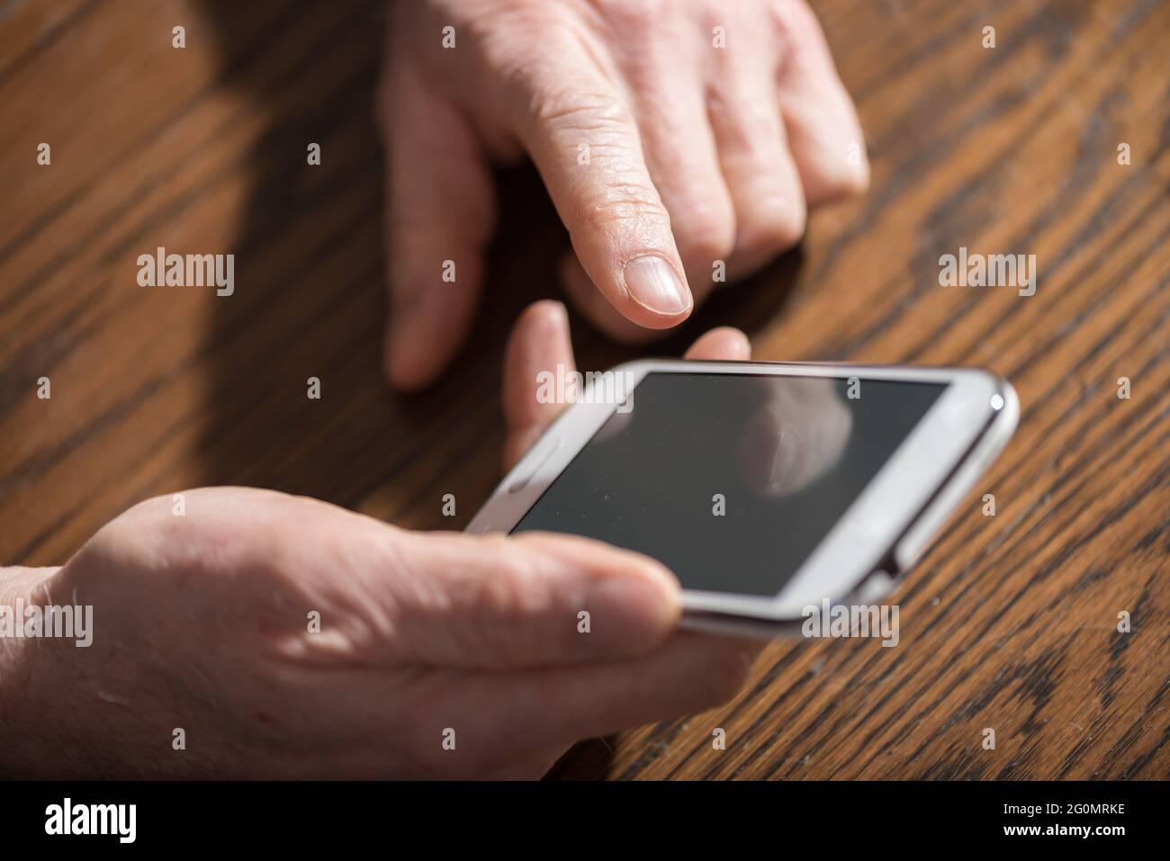 Hand holding a phone, closeup, hard light effect Stock Photo - Alamy