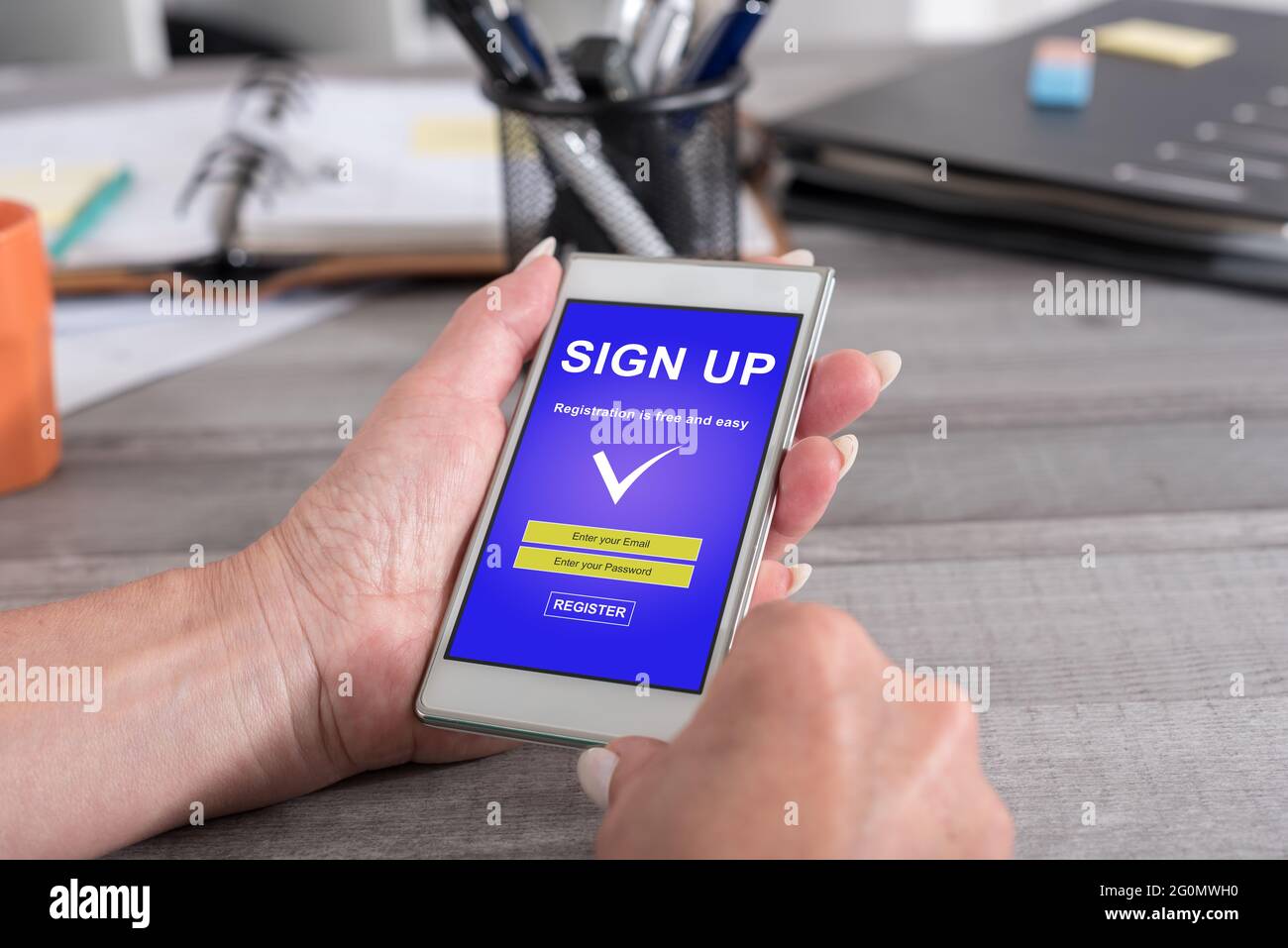 Female hand holding a smartphone with sign up concept Stock Photo - Alamy