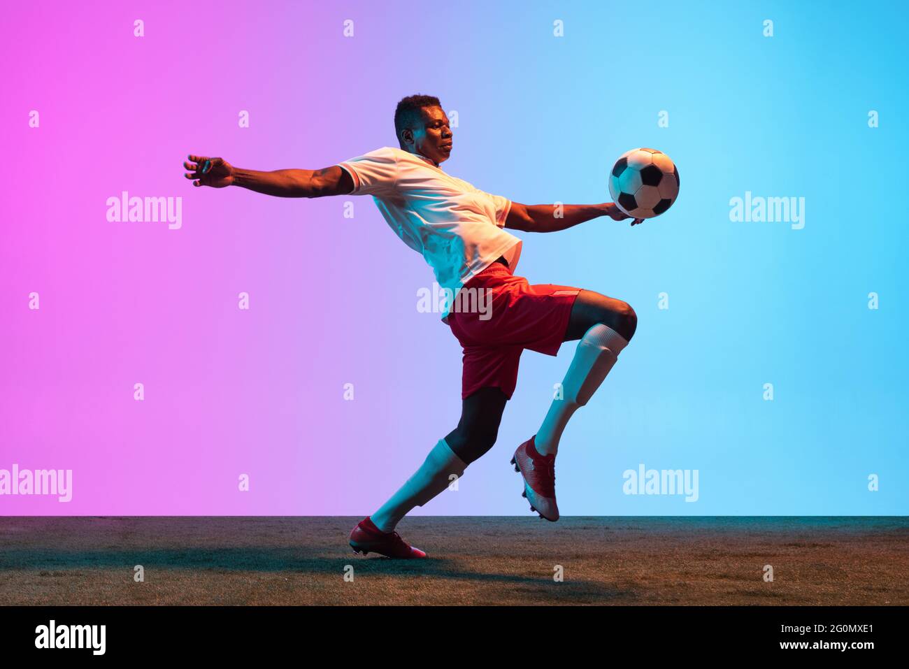 Portrait of African professional football player standing isolated on ...