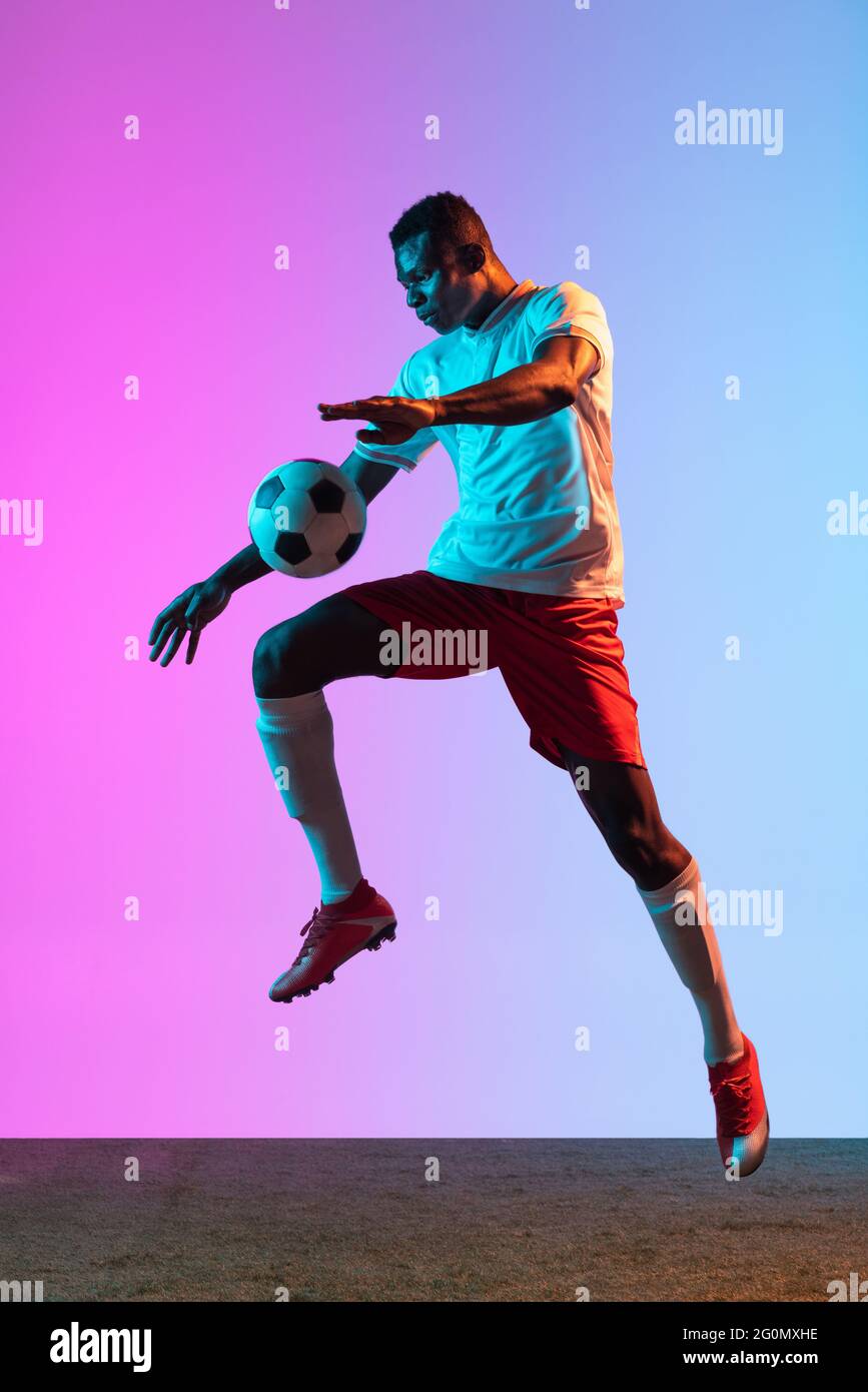 Portrait of African professional football player standing isolated on ...