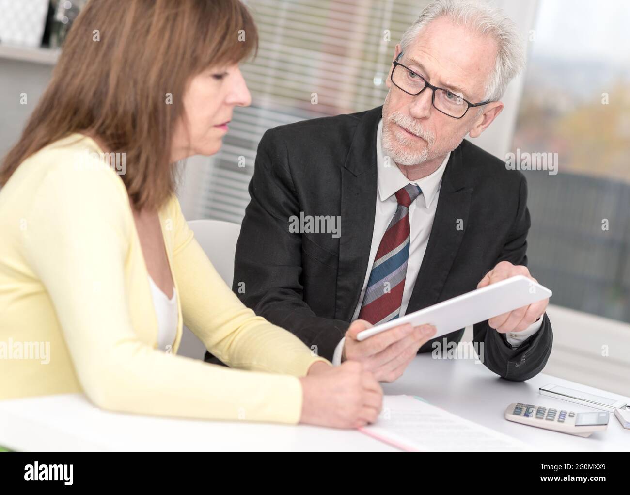 Financial consultant giving advices to female client Stock Photo - Alamy